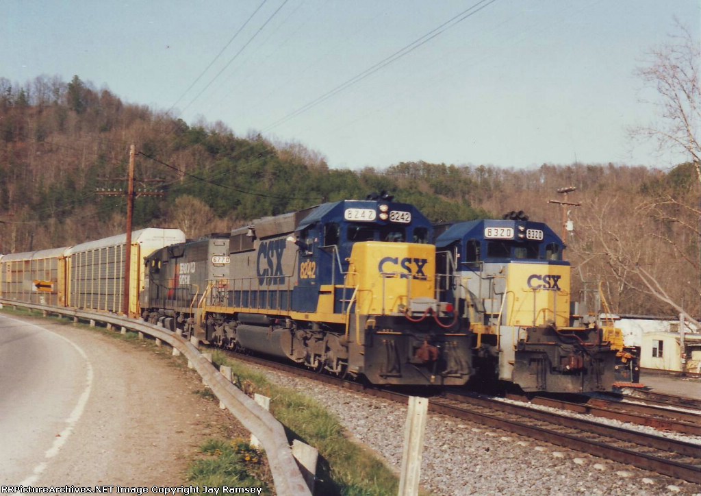 CSX 6770 and 8242 flying past the parked SD40s`